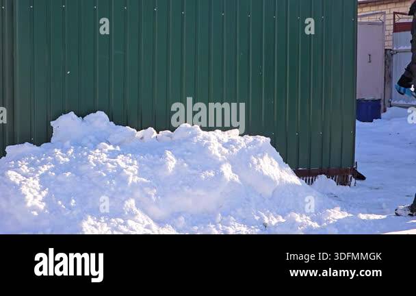 Shoveling snow big blue shovel in the suburb. Clearing a road in winter ...