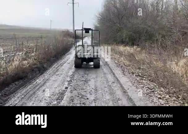 A military ground-based robotic complex drives along the frontline road ...