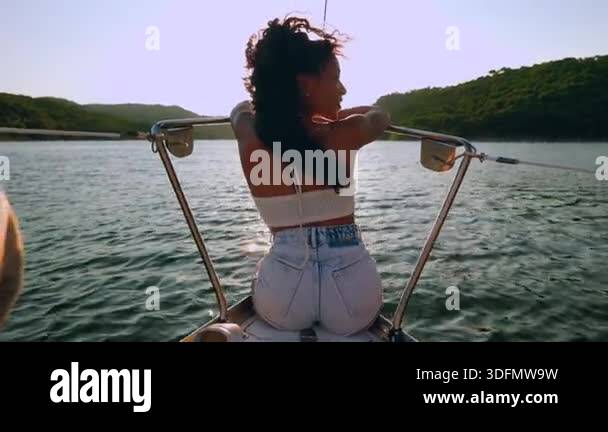 Rear view of a beautiful woman with curly hair enjoying freedom while ...