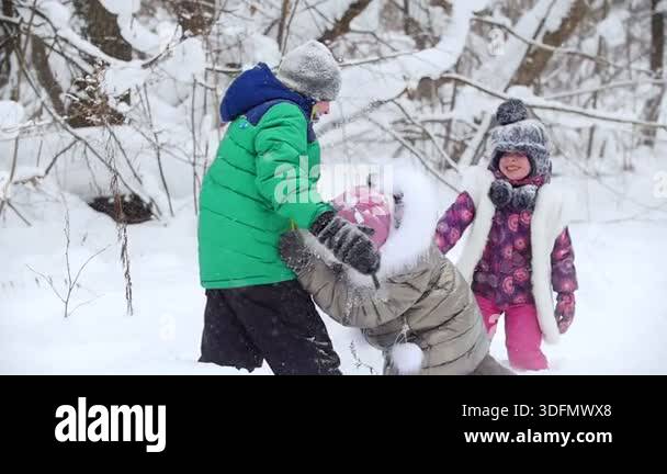 Winter forest. Cheerful smiling children in bright clothes playing with ...