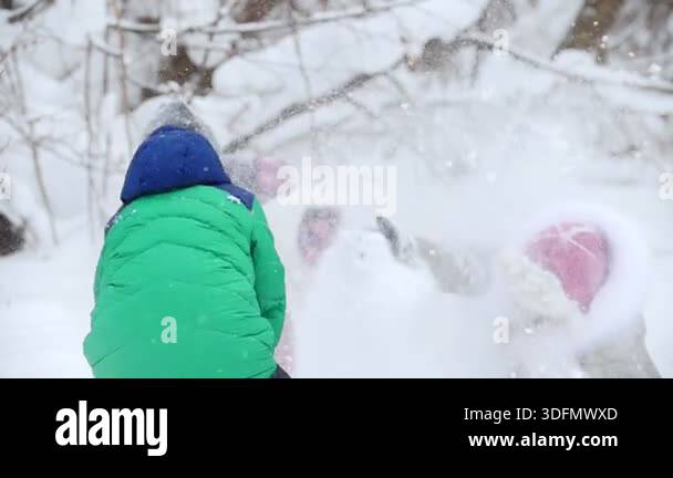 Winter forest. Cheerful children in bright clothes playing with snow ...