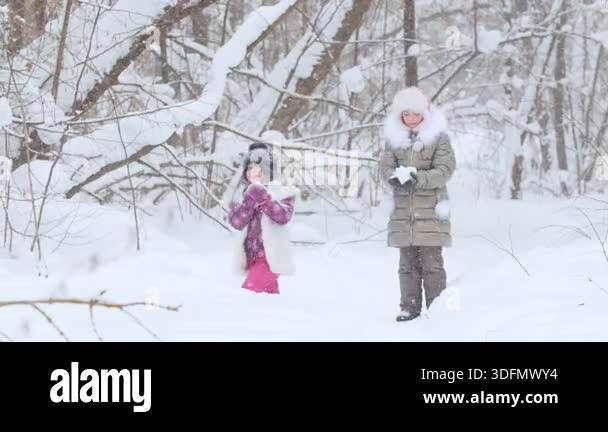 Winter forest. Two little girls throws snow up. Mid shot Stock Video ...