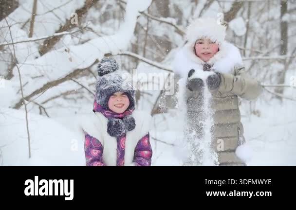 Winter forest. Two happy little girls standing next to each other and ...