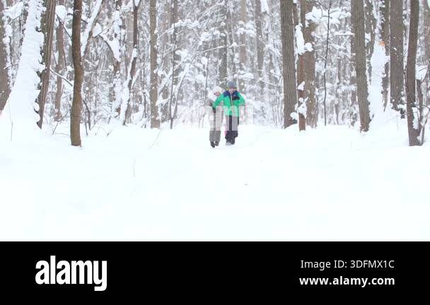 Little kids running after each other in winter forest. Mid shot Stock ...