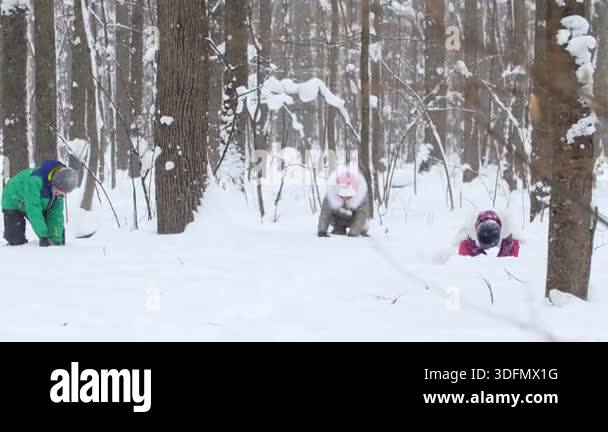 Winter forest. Cheerful children in bright clothes blow up christmas ...