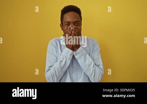 Young african american man standing and laughing with hands covering ...