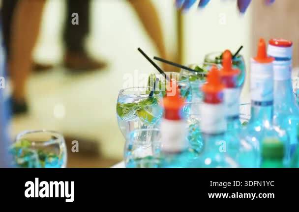 Professional bartender preparing mojito cocktails in a row with people ...