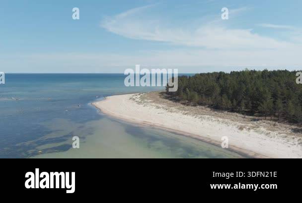 Aerial view of a natural coastline, featuring a long, sandy beach ...