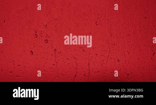 Close up of wet glass with dripping water drops and streaks of rain, on ...