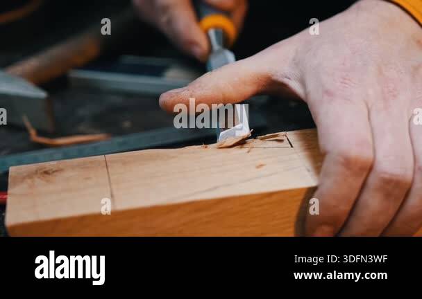 Carpentry industry - a woodworker cutting out the recess on the wooden ...
