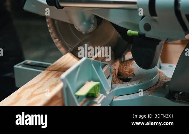 Carpentry industry - a woodworker cutting a piece of wood with a big ...