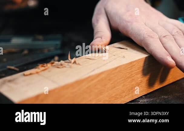 Carpentry industry - a man woodworker cutting out the recess on the ...