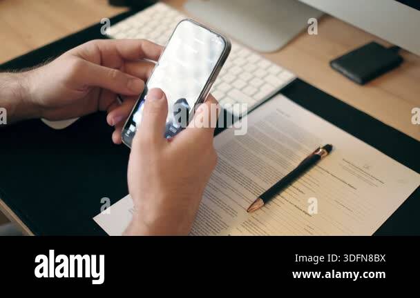 Izmir, Turkey - Jan 9 2026: Video of a man at his desk, holding a phone ...