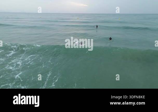 Aerial View Of Surfers In Ocean, Three Surfers In Wetsuits Floating On ...