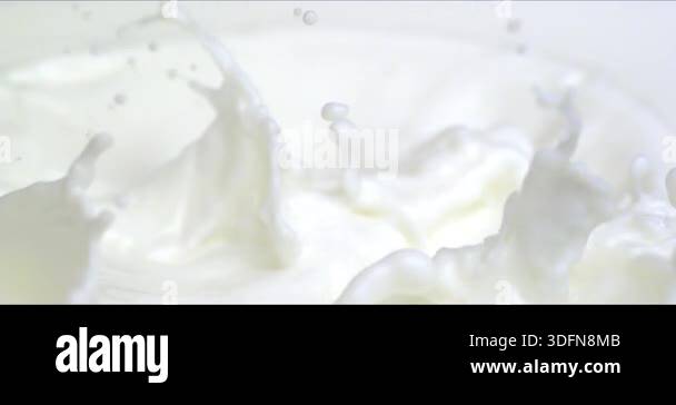 Slow motion almonds falling into milk. Milky splash. Commercial shot ...