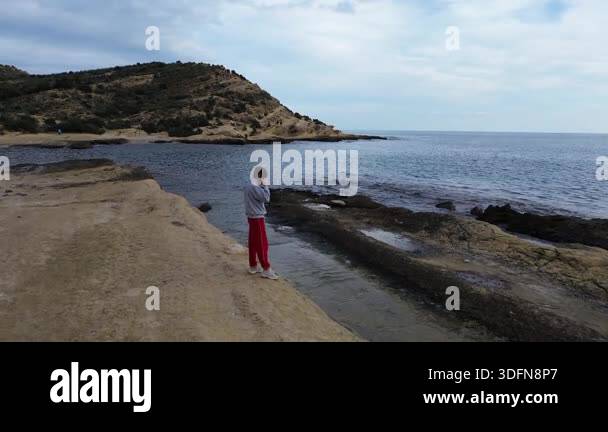 Handsome teenage boy with dark hair in tracksuit talking on mobile ...