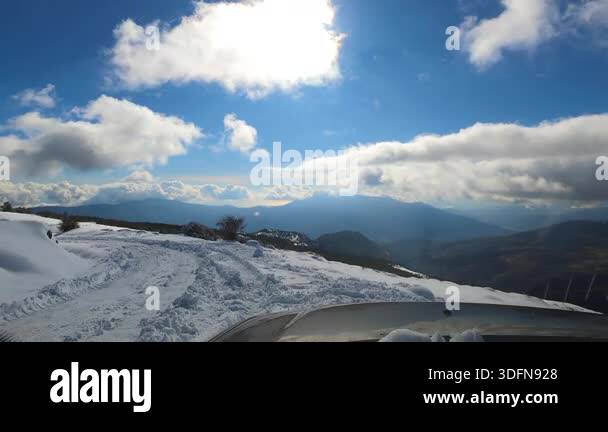 A snow-covered road leads to Parking Hoya del Portillo, revealing ...