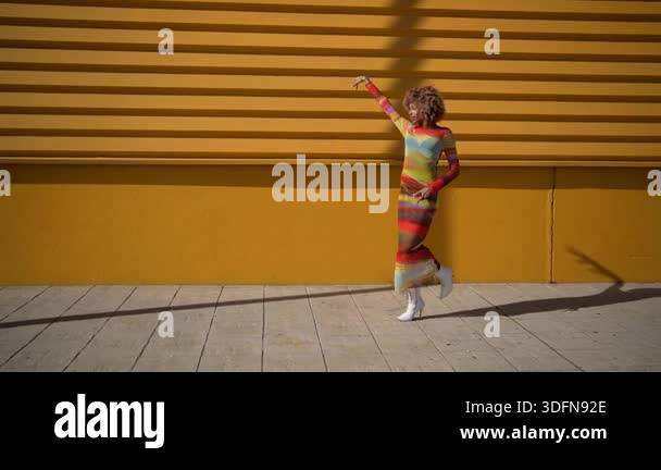 A fashionable model strikes an eyecatching dynamic pose in front of a ...