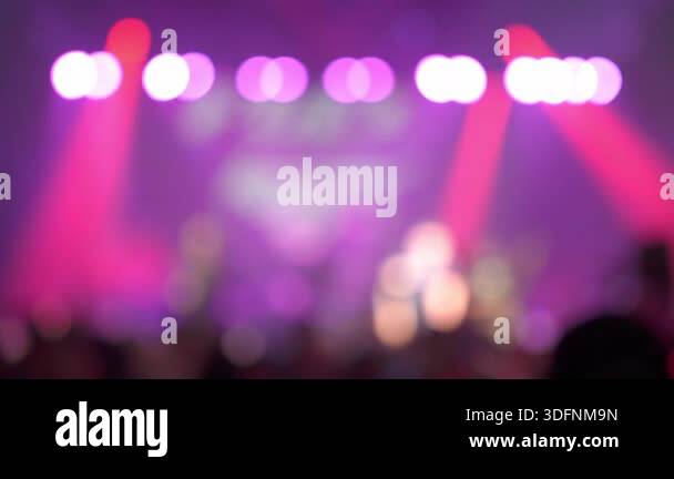 Defocused concert stage with purple and pink lights creating bright ...