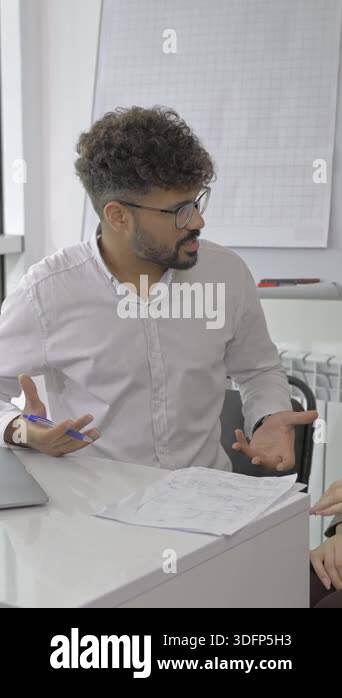 Concentrated male entrepreneur gesturing while explaining a business ...
