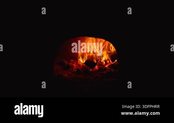 Bright orange flames and glowing embers burning inside a traditional ...