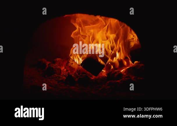 Bright orange flames and glowing embers burning inside a traditional ...