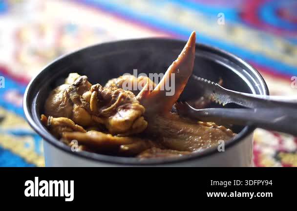 Serving process of boiled chicken wings using tongs, illustrating a ...