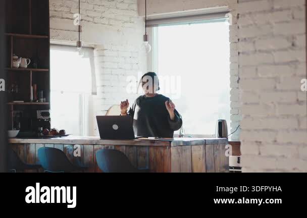 Joyful woman enjoying a short break from remote work, dancing and ...