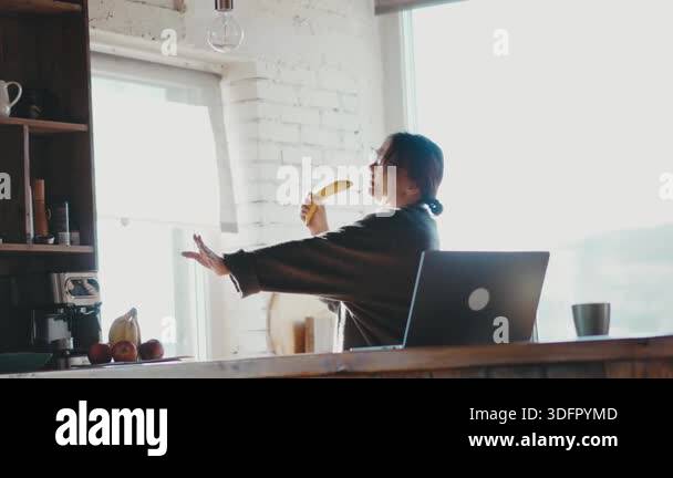 Joyful woman enjoying a short break from remote work, dancing and ...