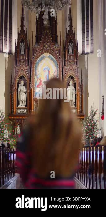Back view of people attending a Catholic Christmas mass with icons ...
