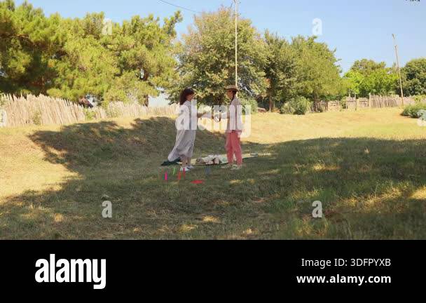Mother and daughter enjoy playful ring toss at a weekend picnic. Summer ...