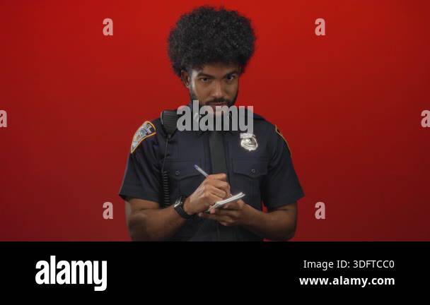 African american male police officer in uniform writing on a notepad ...