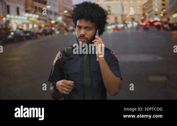 African american police officer in uniform talks on smartphone in ...