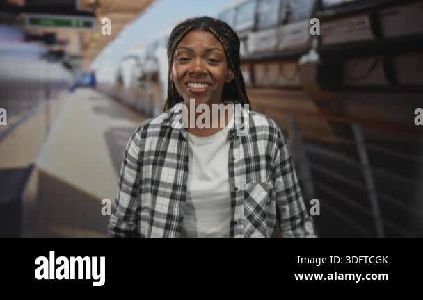 Woman smiling with teeth and thumbs pointing to chest in a building ...