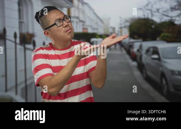 Man young with palms up hands gesture on a city street wearing red ...