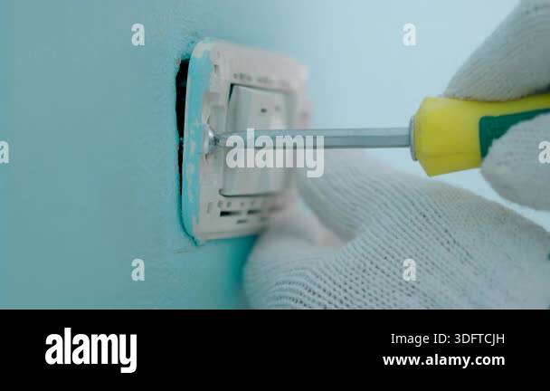 Close-up hand of man wearing cloth gloves and uses a screwdriver to ...