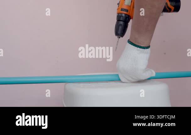 Close-up hand of man wearing cloth gloves and using a cordless drill to ...