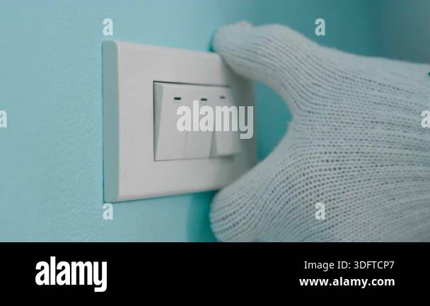 Close-up hand of man wearing cloth gloves and opening light switch ...