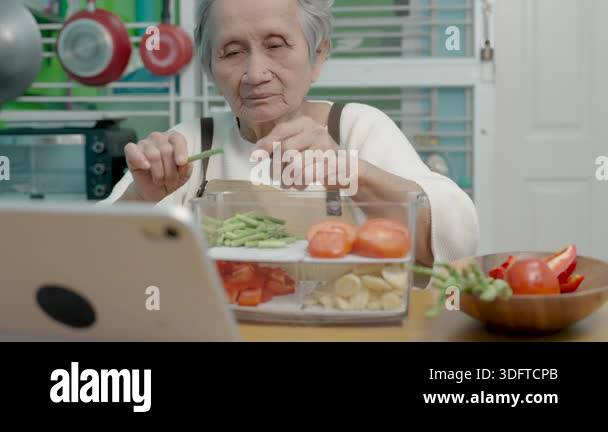 Seniors woman are cooking in their home kitchen and looking at digital ...