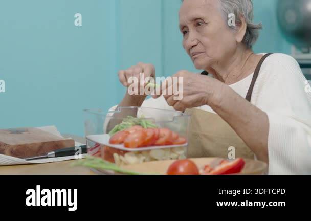 Seniors woman are cooking in their home kitchen and looking at digital ...