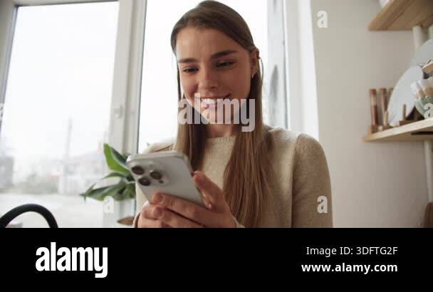 Happy young woman texting on her mobile phone, scrolling social media ...