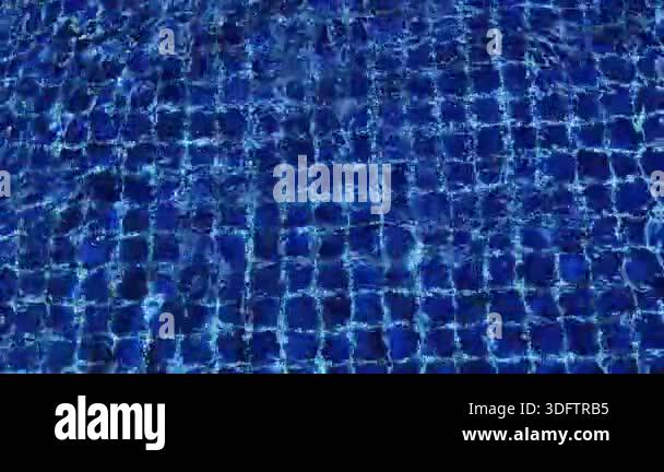 4K slow motion footage swimming pool with deep blue tiles. Sunlight ...