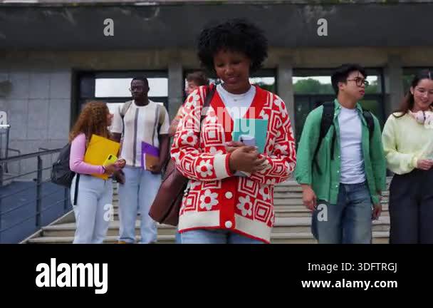 African American girl and a Group of diverse university students walk ...