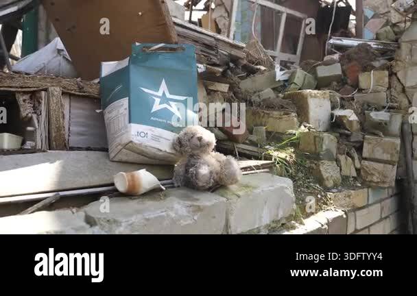 Dirty teddy bear sits beside russian military ration package among ...