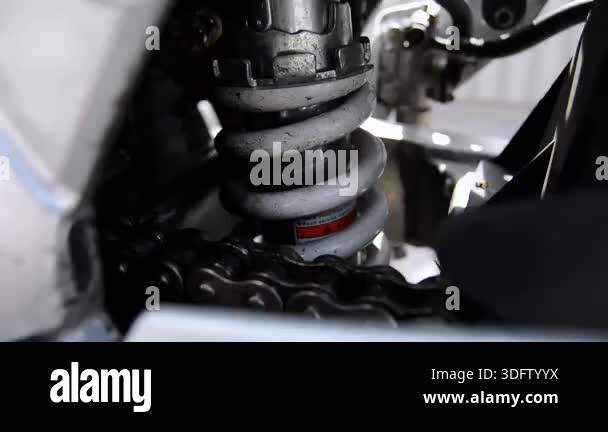 Close-up of a motorcycle suspension system showing a coil spring and ...