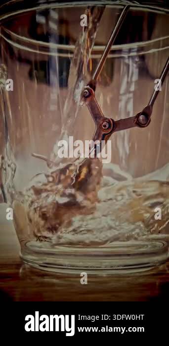 Tea Infuser Plunging Into Glass, Warm Amber Liquid Erupts In SlowMotion ...