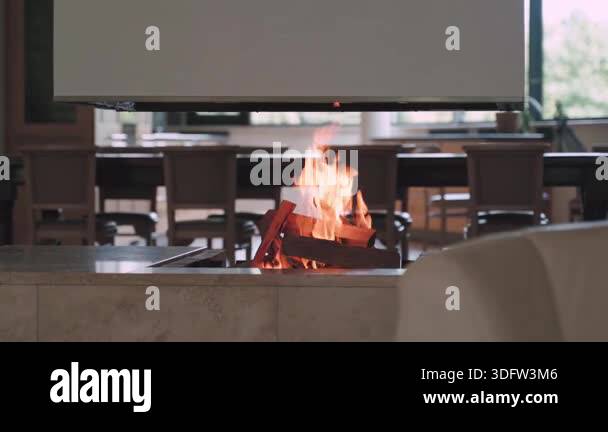 Modern indoor fireplace with natural wood fire in a luxury spa lounge ...