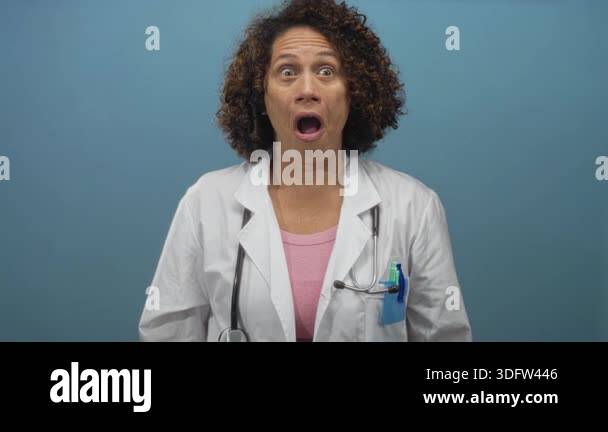 Woman doctor wearing lab coat and stethoscope covers mouth with both ...