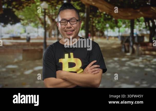 Man in bitcoin t shirt, young and smiling with glasses, arms crossed in ...