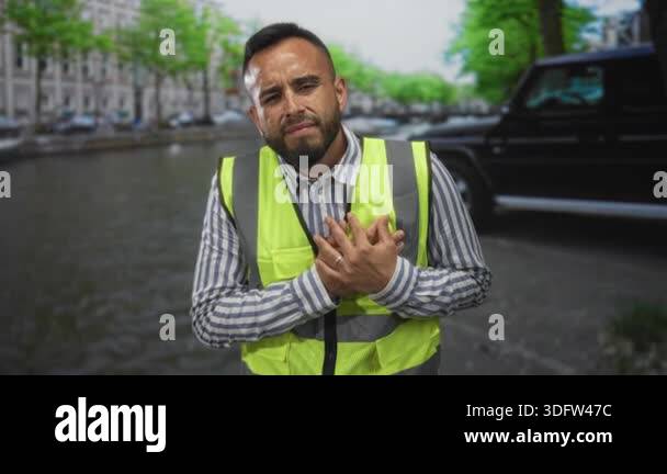 Man clutching chest with both hands on a street by an amsterdam canal ...